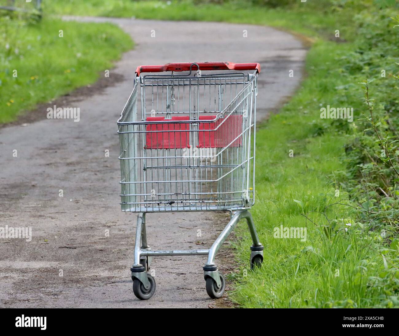A shopping cart sits on the side of a dusty road Stock Photo - Alamy