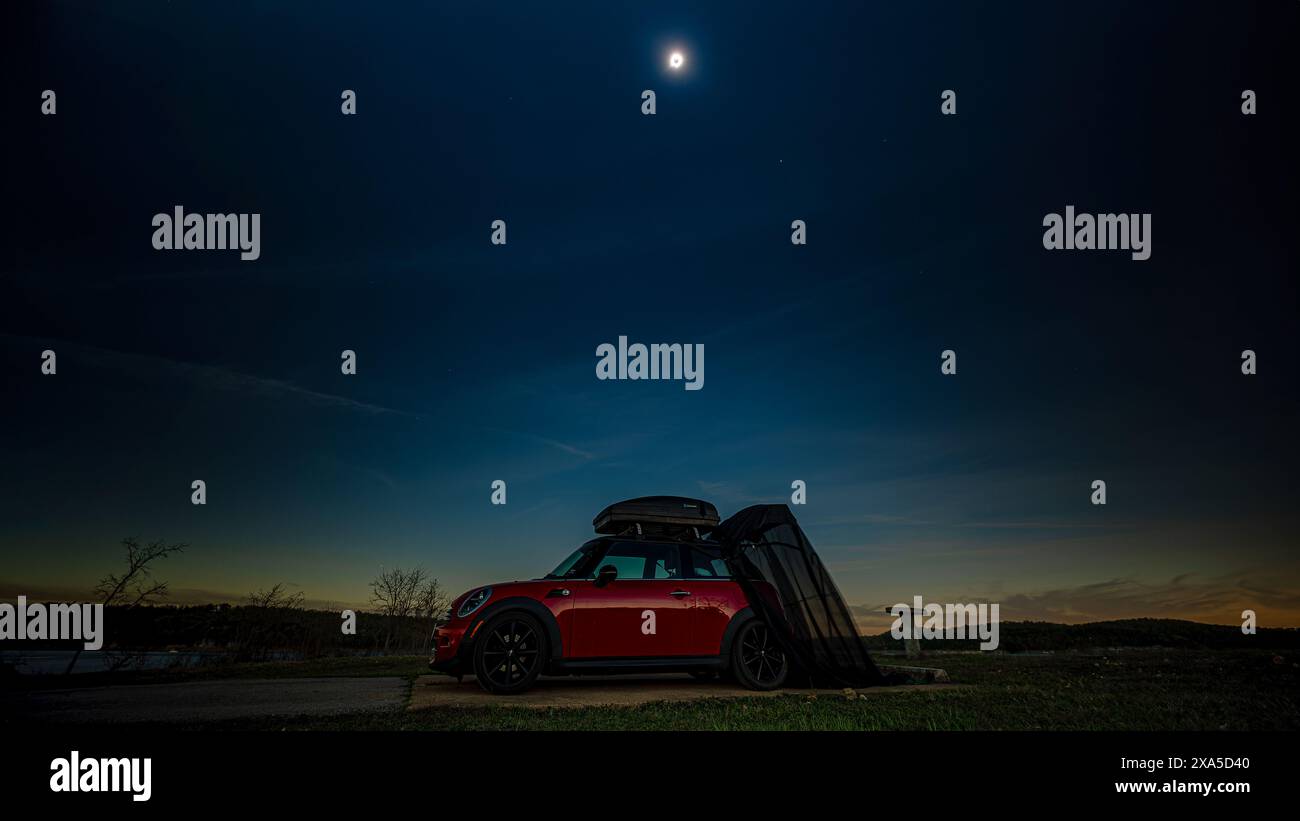 A car parked beneath a bright moon over water Stock Photo - Alamy