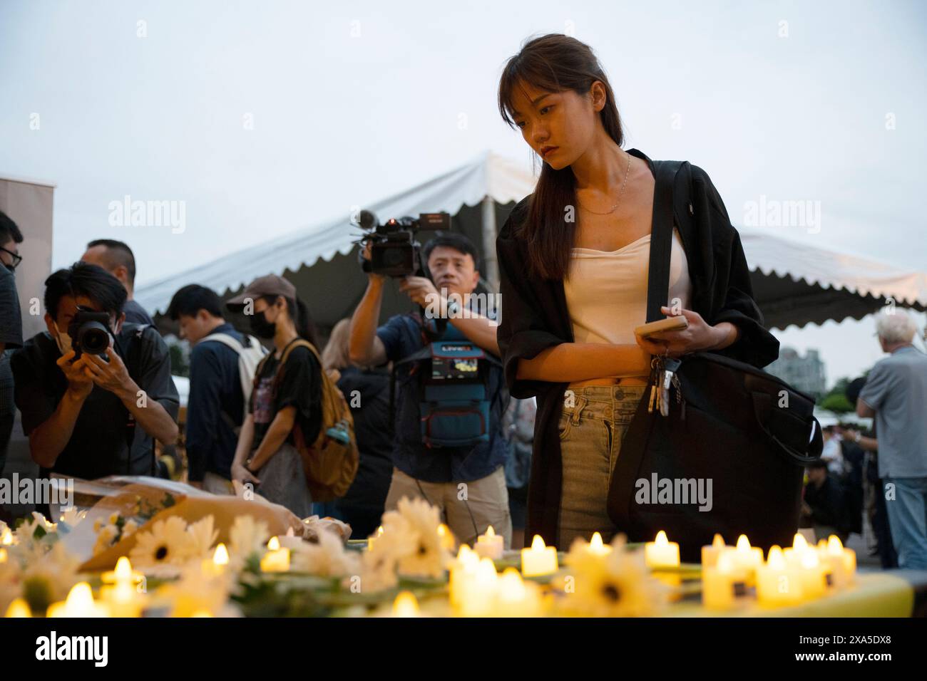 Taipei, Taiwan. 4th June, 2024. A woman observes flowers and flameless ...