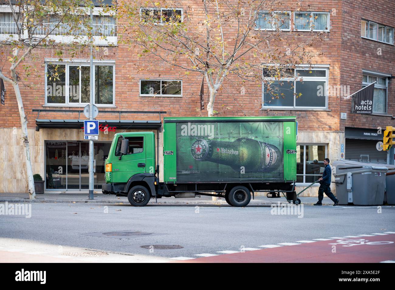 Side view of a green Heineken beer delivery truck stopped on a corner ...