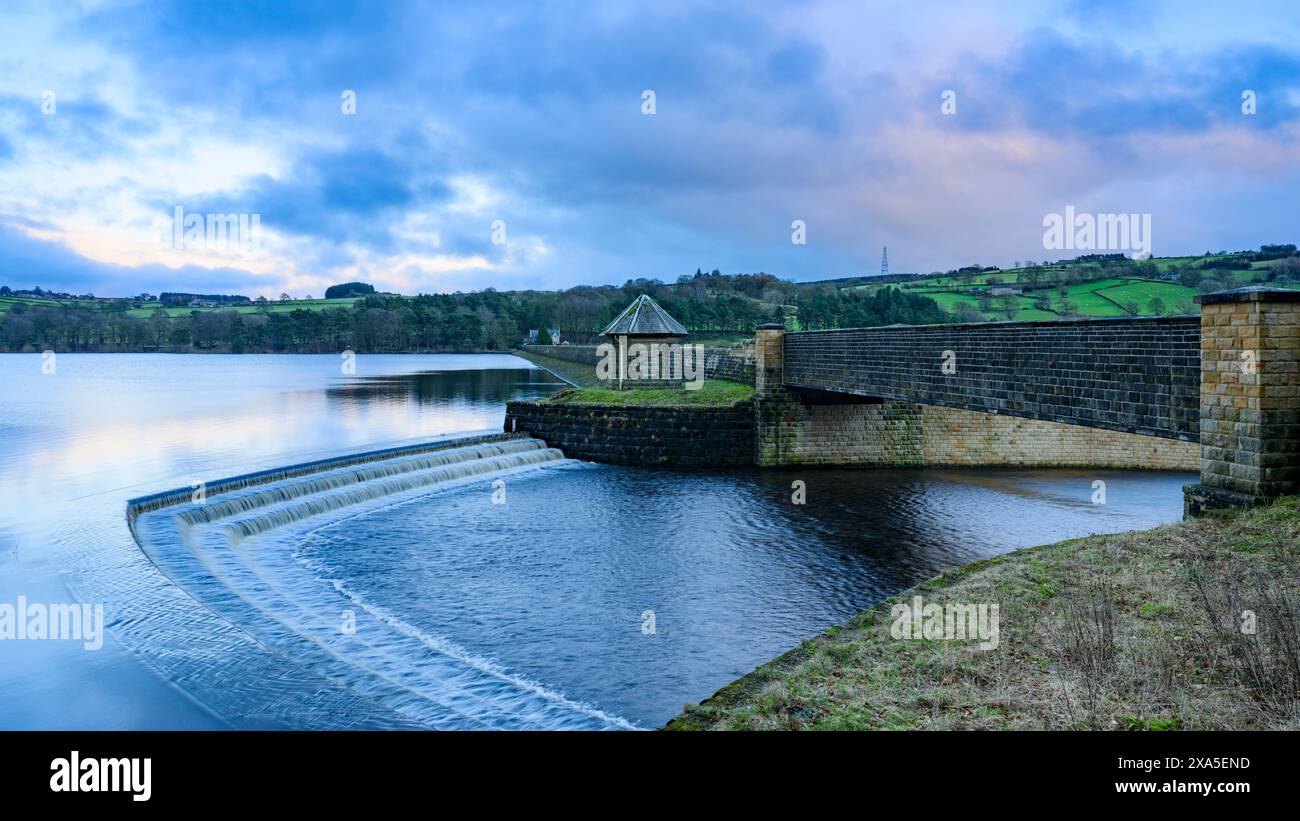 Water tumbling down steps from calm scenic man-made lake, under stone ...