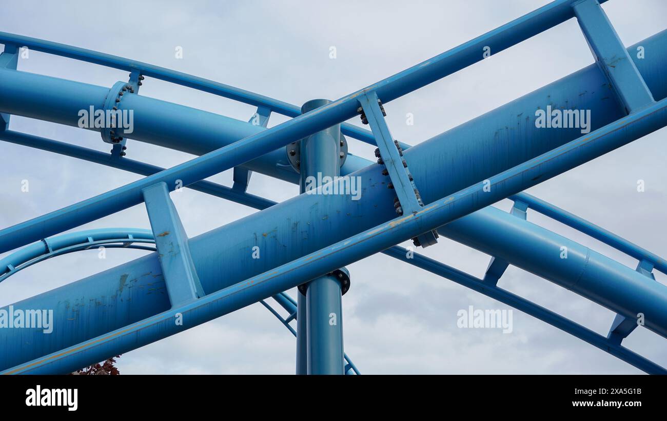 Two blue-colloured roller coaster tracks crossing each other, at the ...