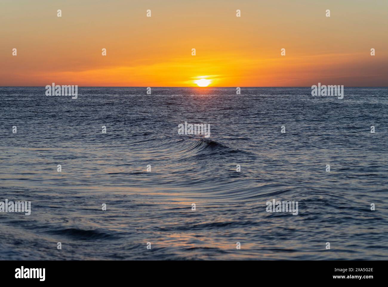 An incredible sunrise unfolds over the beach, stretching to an infinite ...