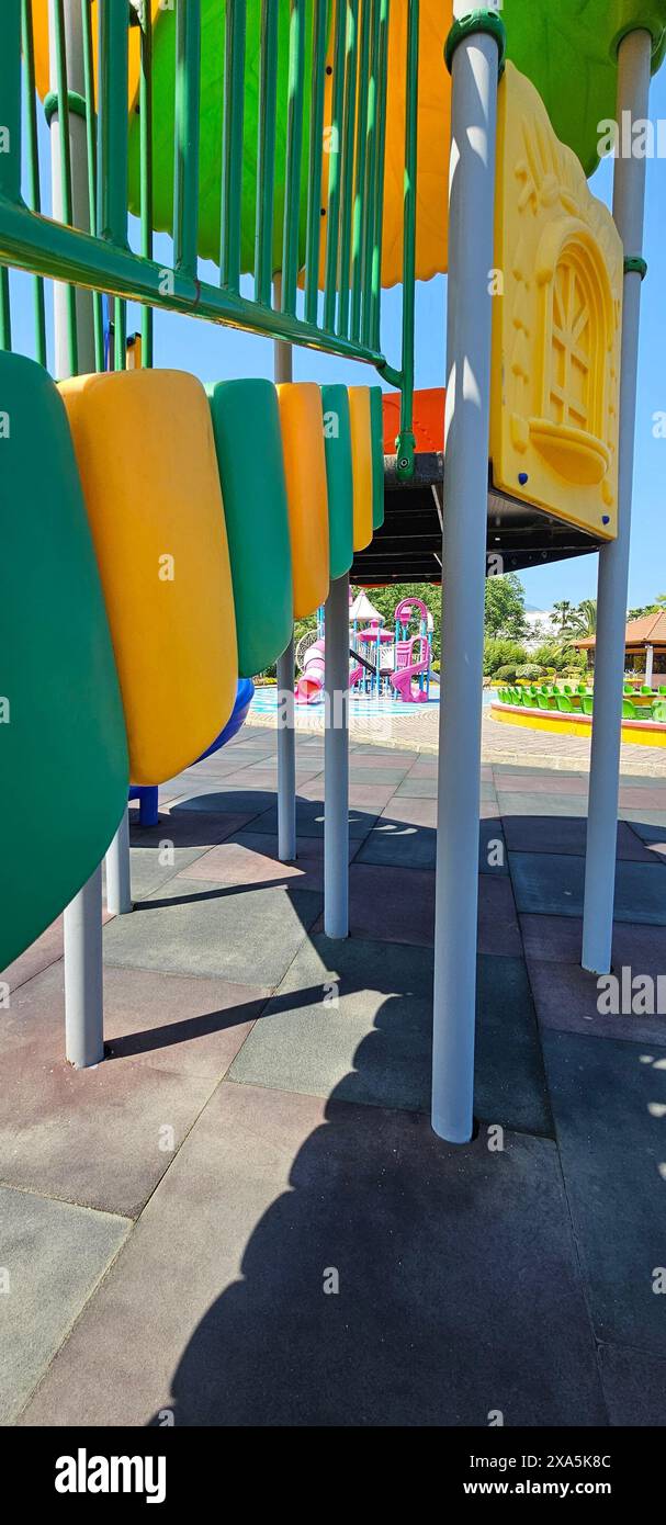 A multi-colored playground structure with slides beneath Stock Photo ...