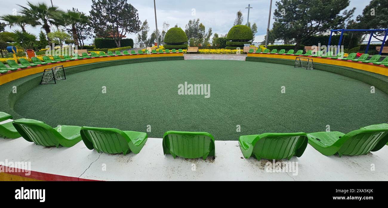 An outdoor seating area with green lawn chairs and benches in front of ...