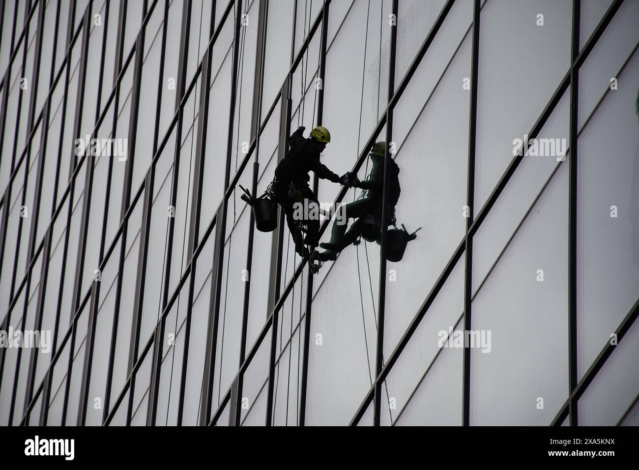 A Window cleaner man in the air, cleaning skyscraper windows in Poland ...