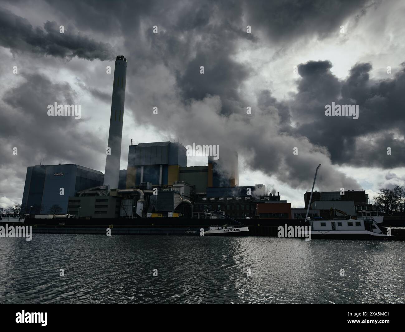 Two boats on the water near industrial buildings and factory Stock ...