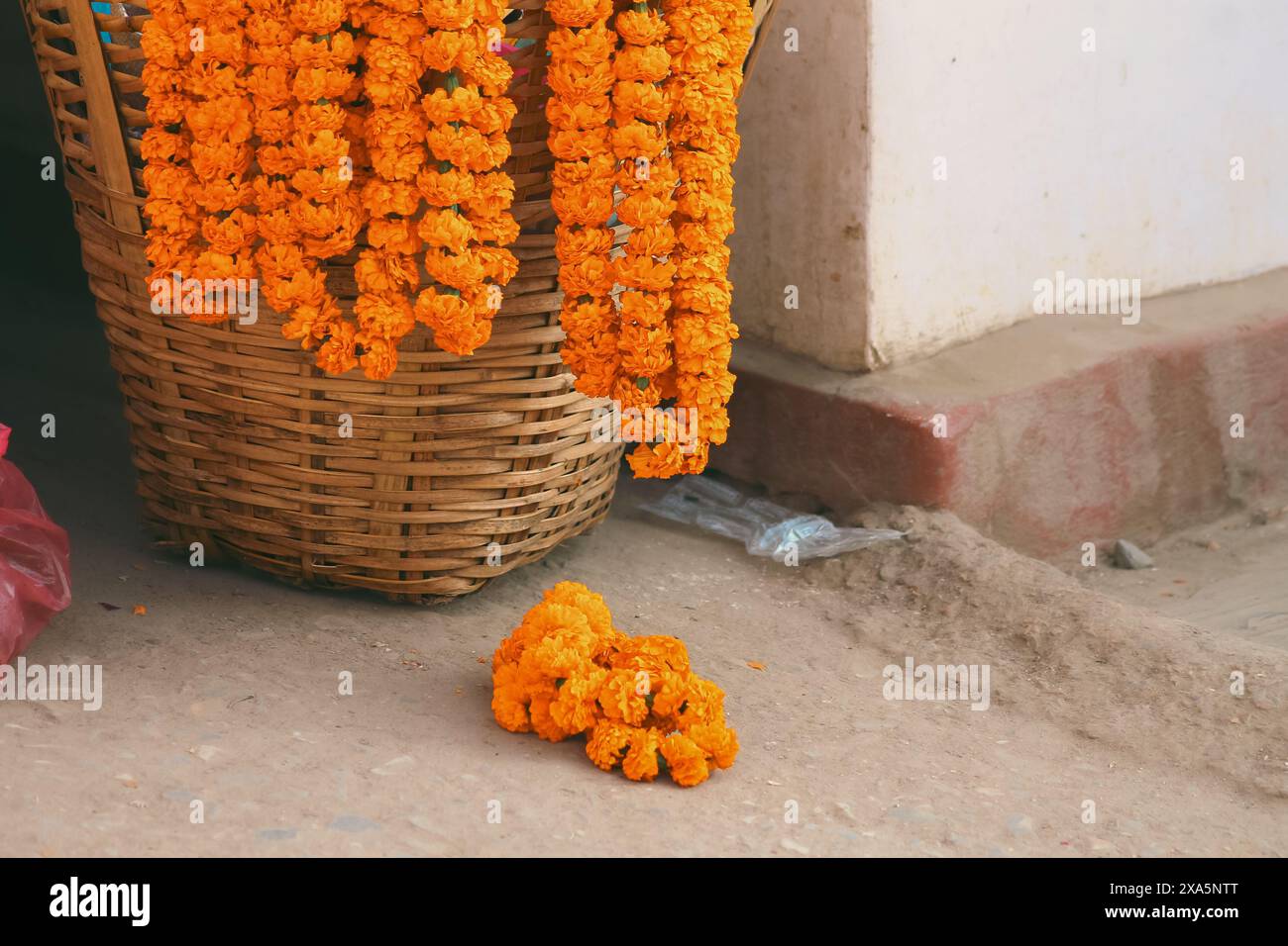 Marigold flower garlands hung on an empty woven basket it used as ...