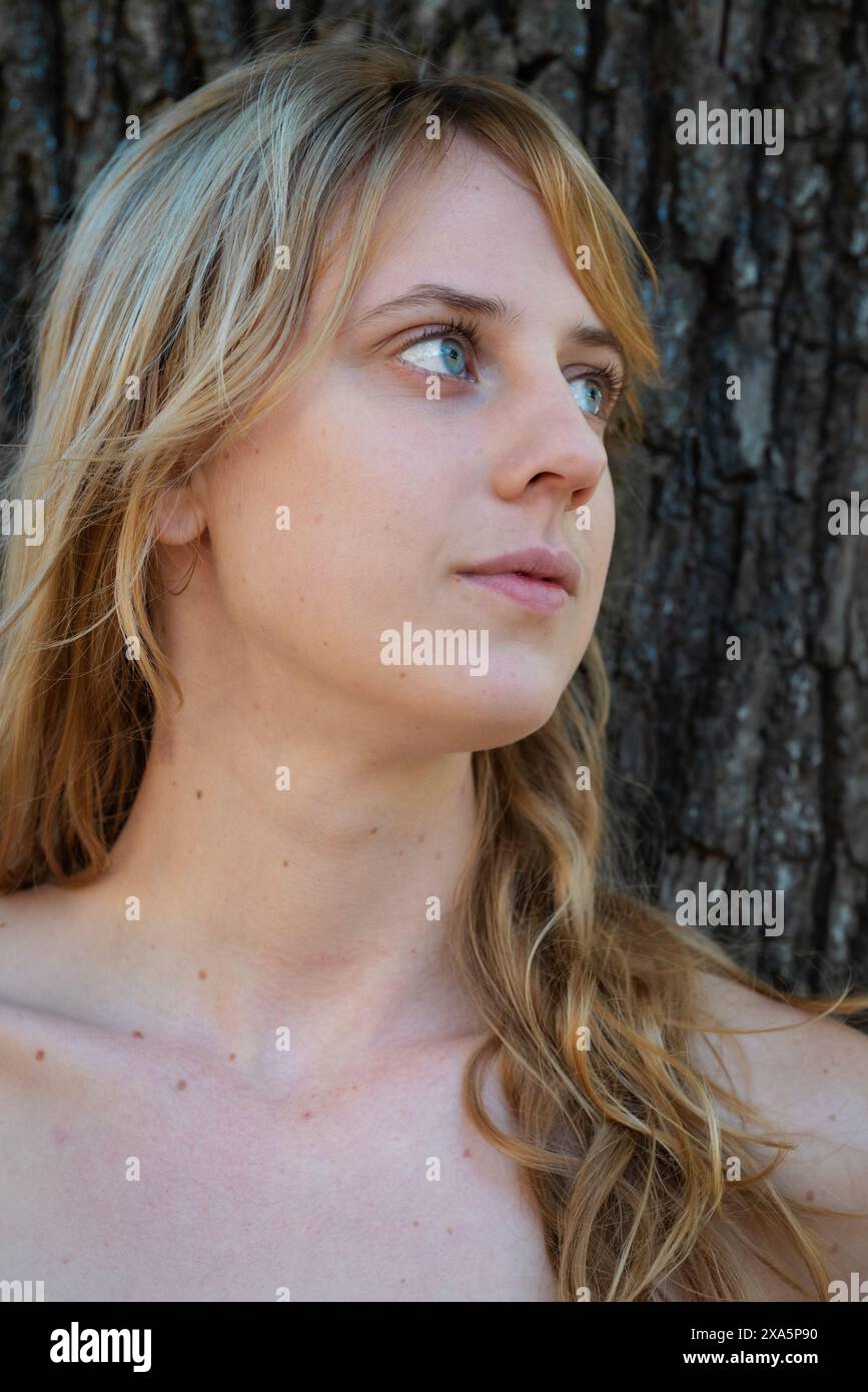 A closeup of a blonde girl posing in a park or natural area Stock Photo ...