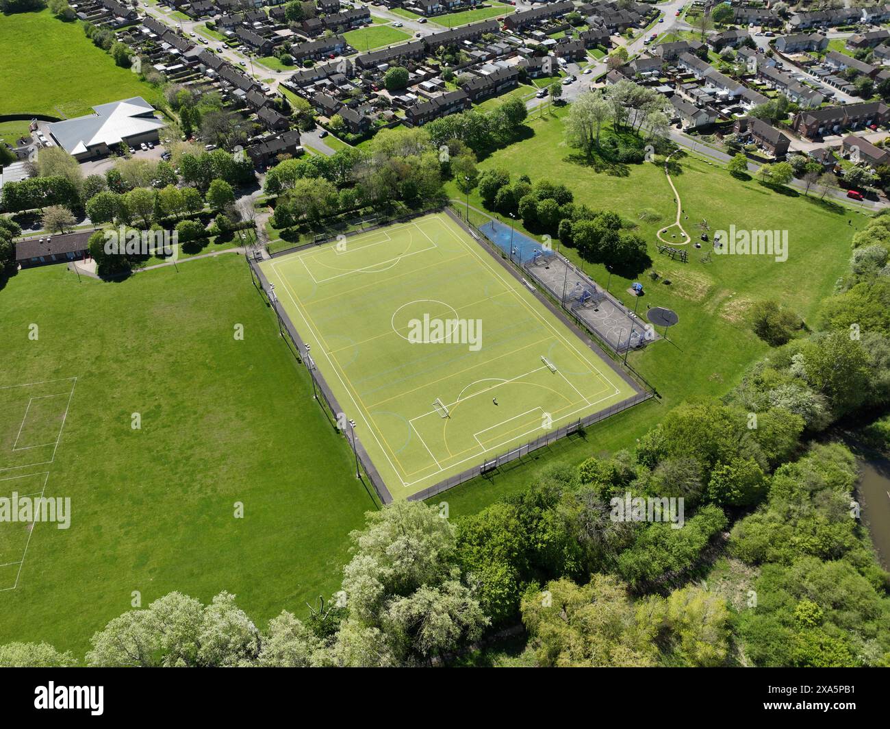 An aerial shot of a green football pitch surrounded by a field and ...