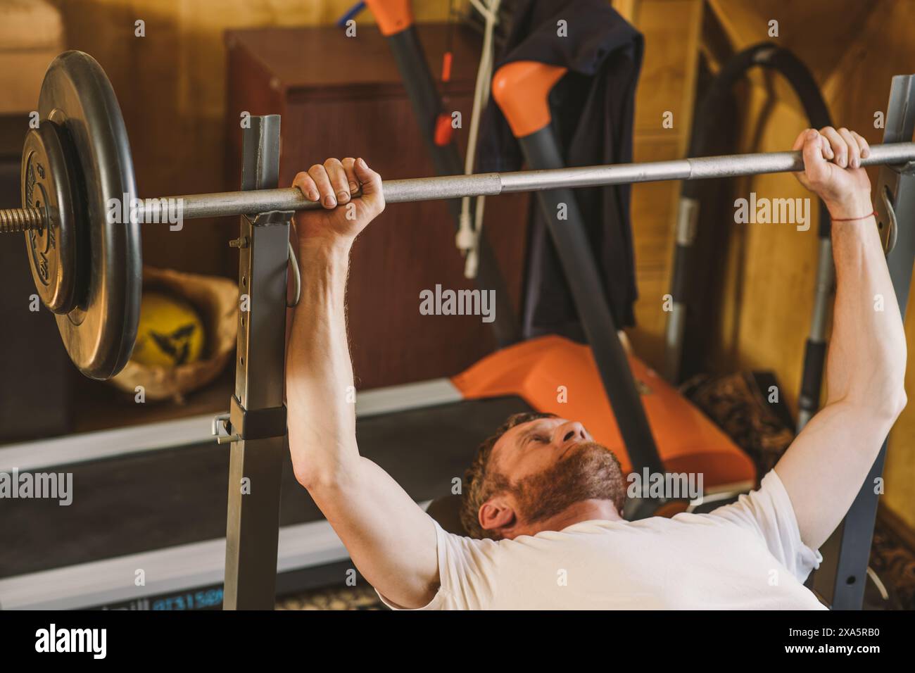 A man doing a bench press with a barbell in the gym Stock Photo - Alamy