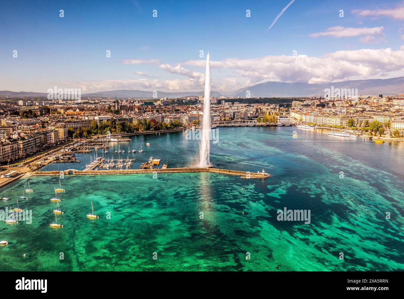 A scenic aerial view of Geneva's water fountain with boats in the ...