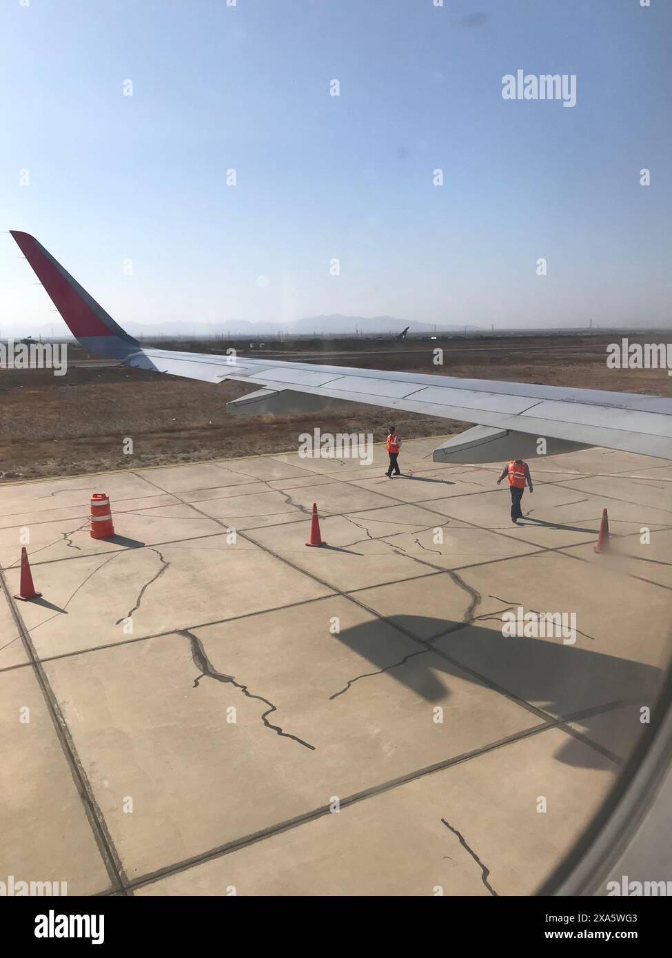 Ground crew member directing an airplane on the airport apron, seen ...