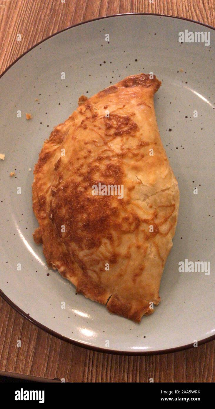 Top view of a deliciously baked calzone with a crisp crust, served on a ...