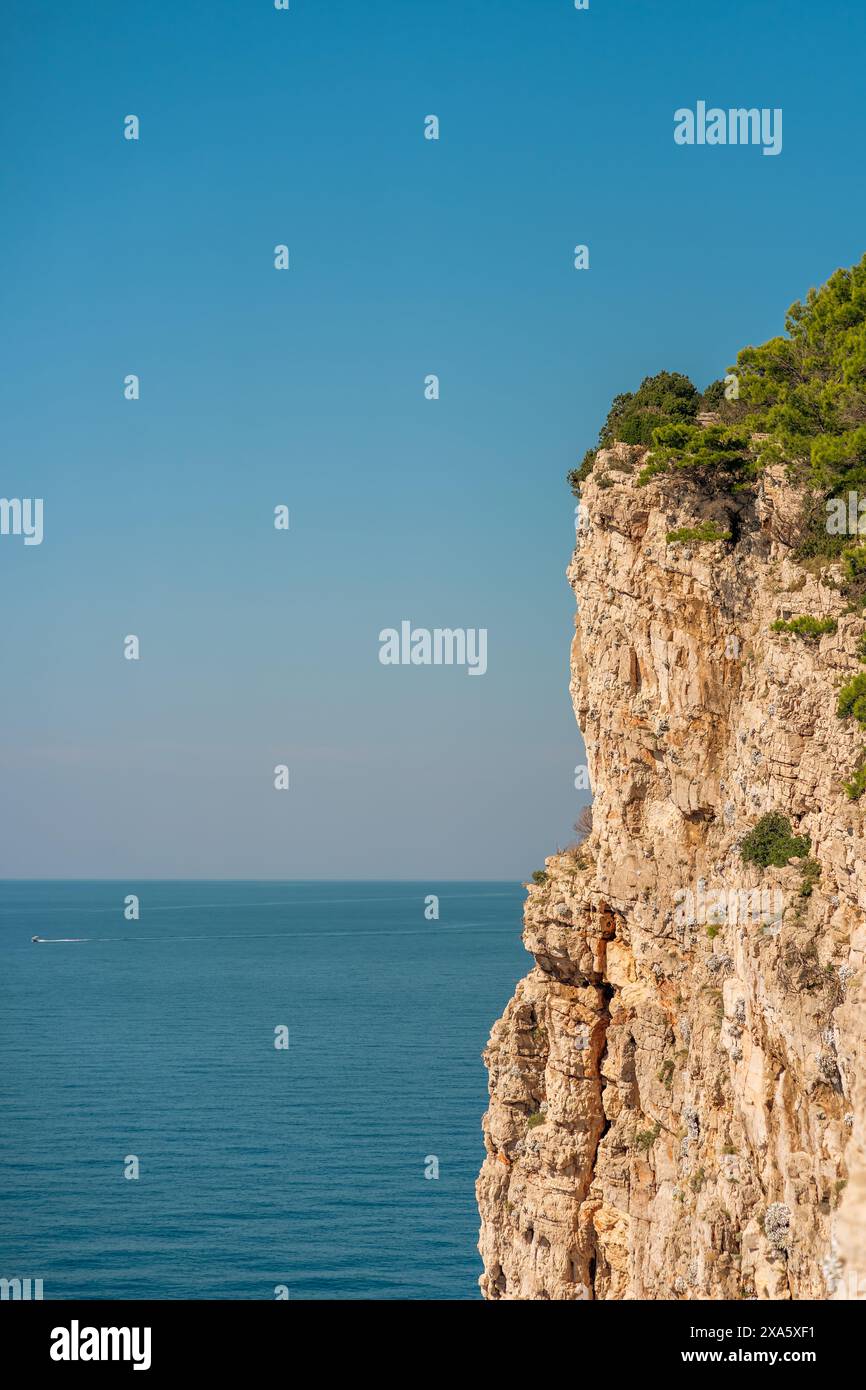 Sheer cliff in sunlight, blue water and clear sky of Dugi Otok island ...