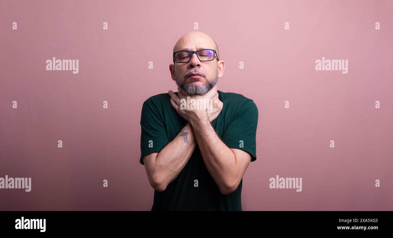 Bearded Bald Man With Prescription Glasses Squeezing His Neck With Both