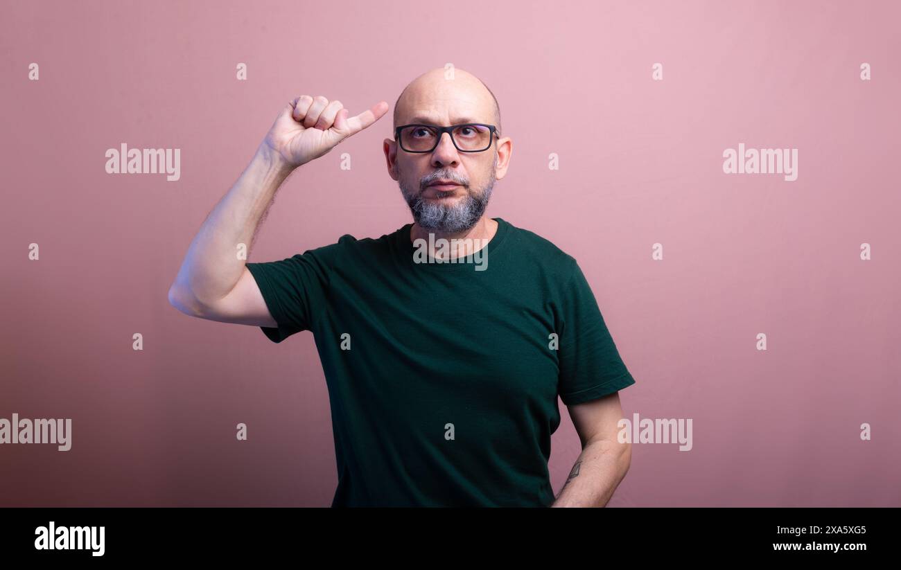 Bearded Bald Man Wearing Prescription Glasses Pointing To His Head With