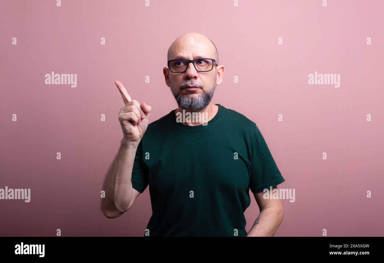 Bearded Bald Man With Prescription Glasses Pointing With His Finger To