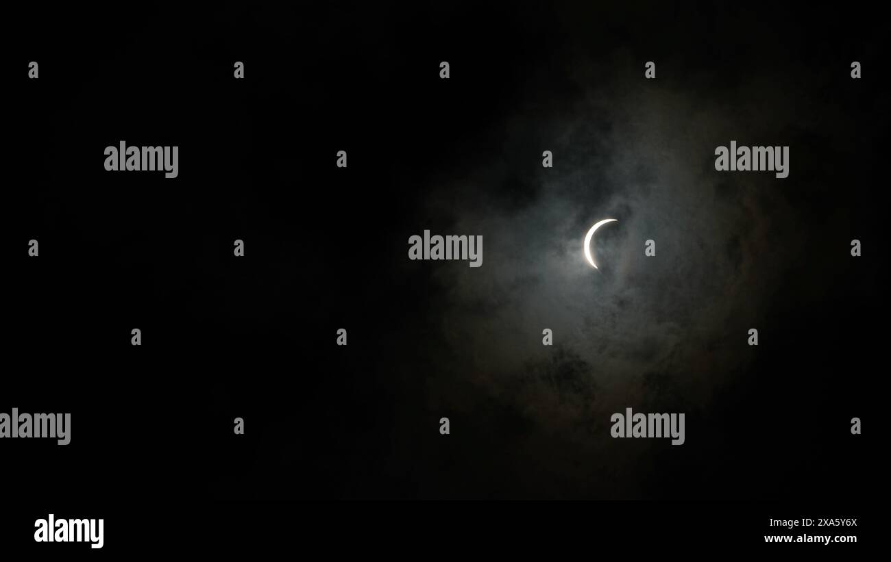 The solar eclipse with the moon shining through dark clouds in Waco, Texas Stock Photo - Alamy