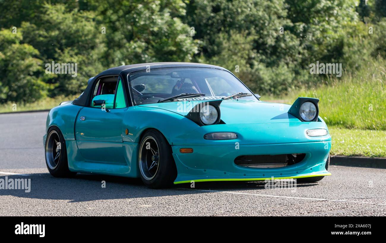 Stony Stratford,UK - June 2nd 2024: 1992 Mazda MX-5 with pop up headlights car driving on a ...