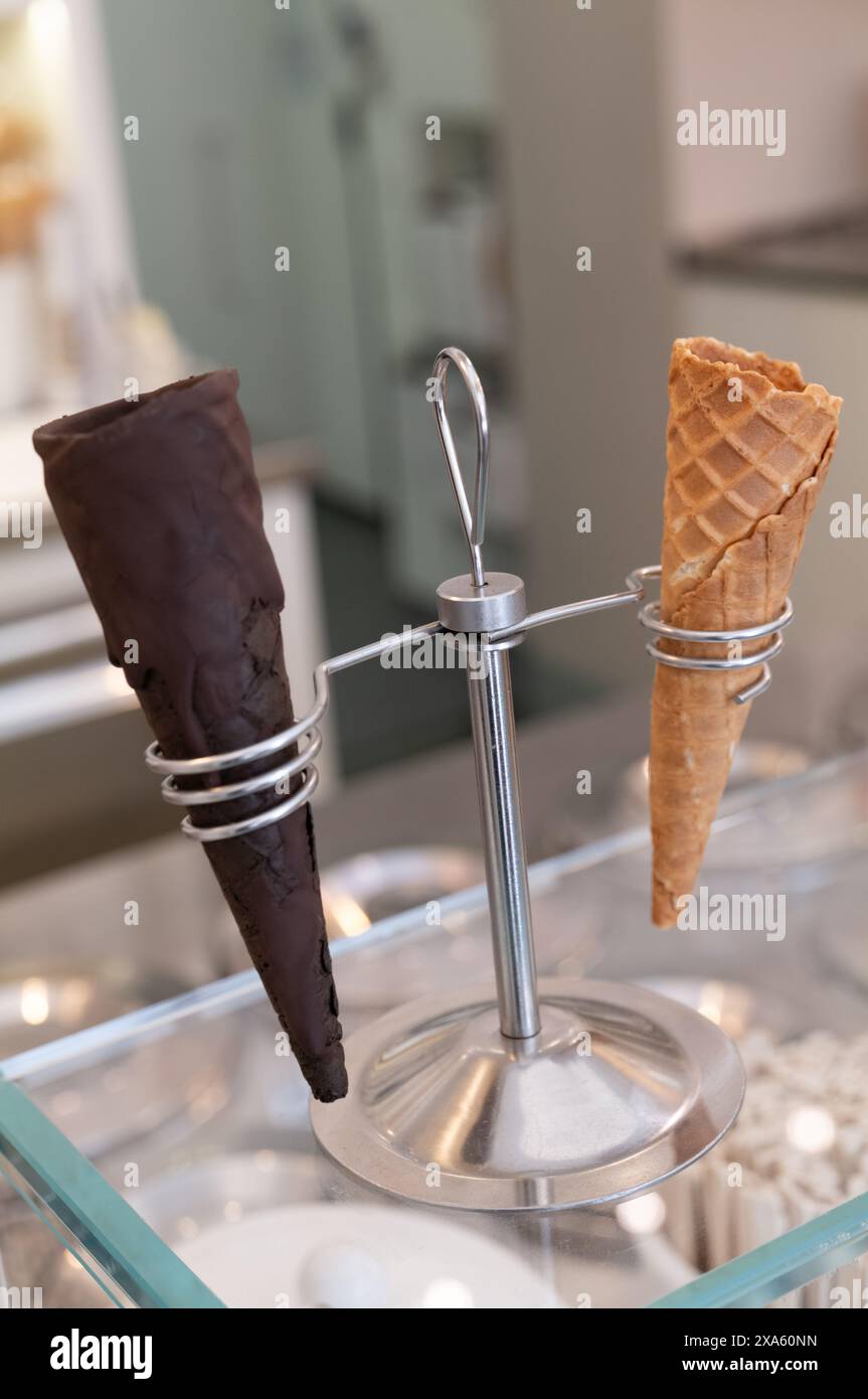The two ice cream cones displayed on a silver rack on a glass table ...