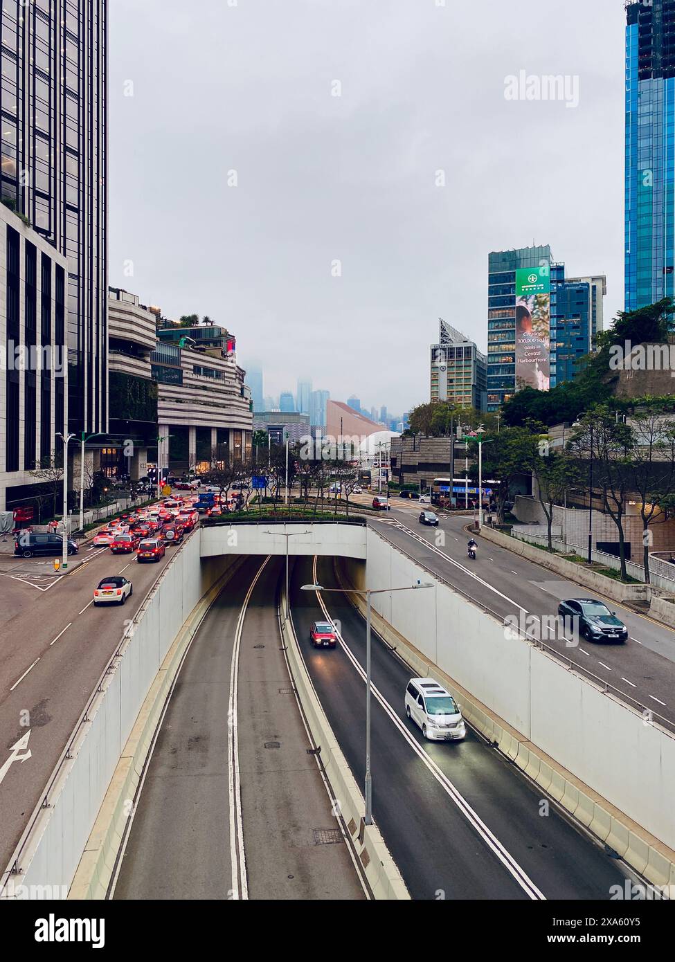 Urban scene with multiple cars driving on a busy city street lined with ...