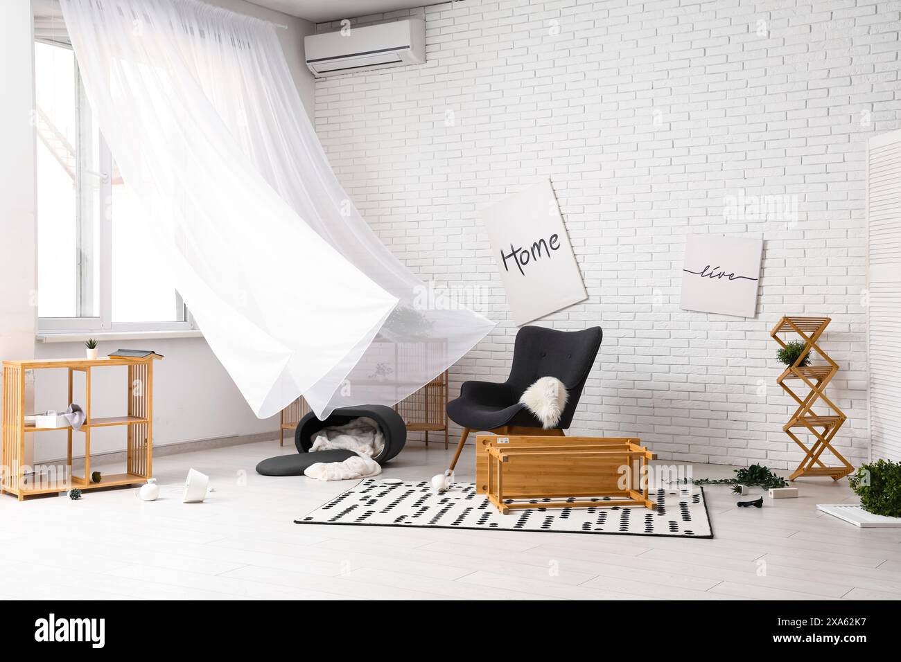 Interior of messy living room with armchair and overturned coffee table ...