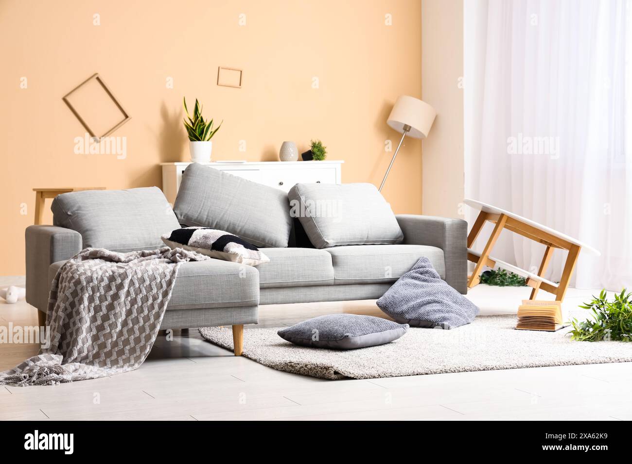 Interior of messy living room with sofa and pillows on carpet Stock ...