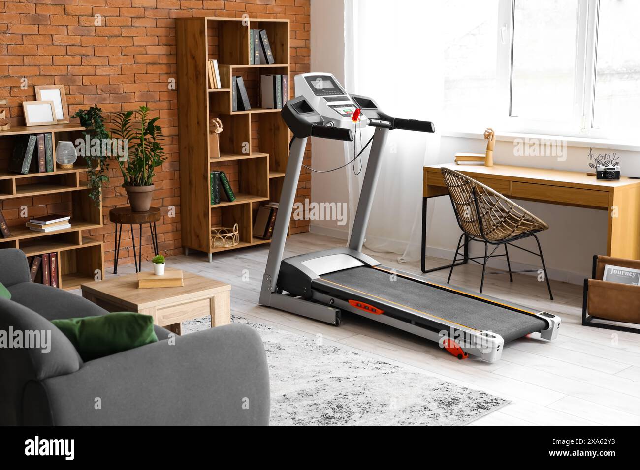 Interior of living room with treadmill, table and shelf units Stock ...