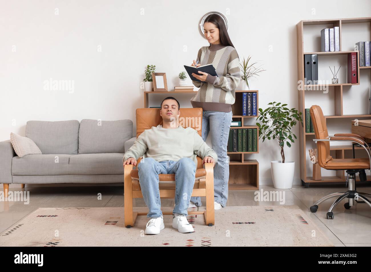 Female psychologist with notebook and hypnotized man in office Stock ...