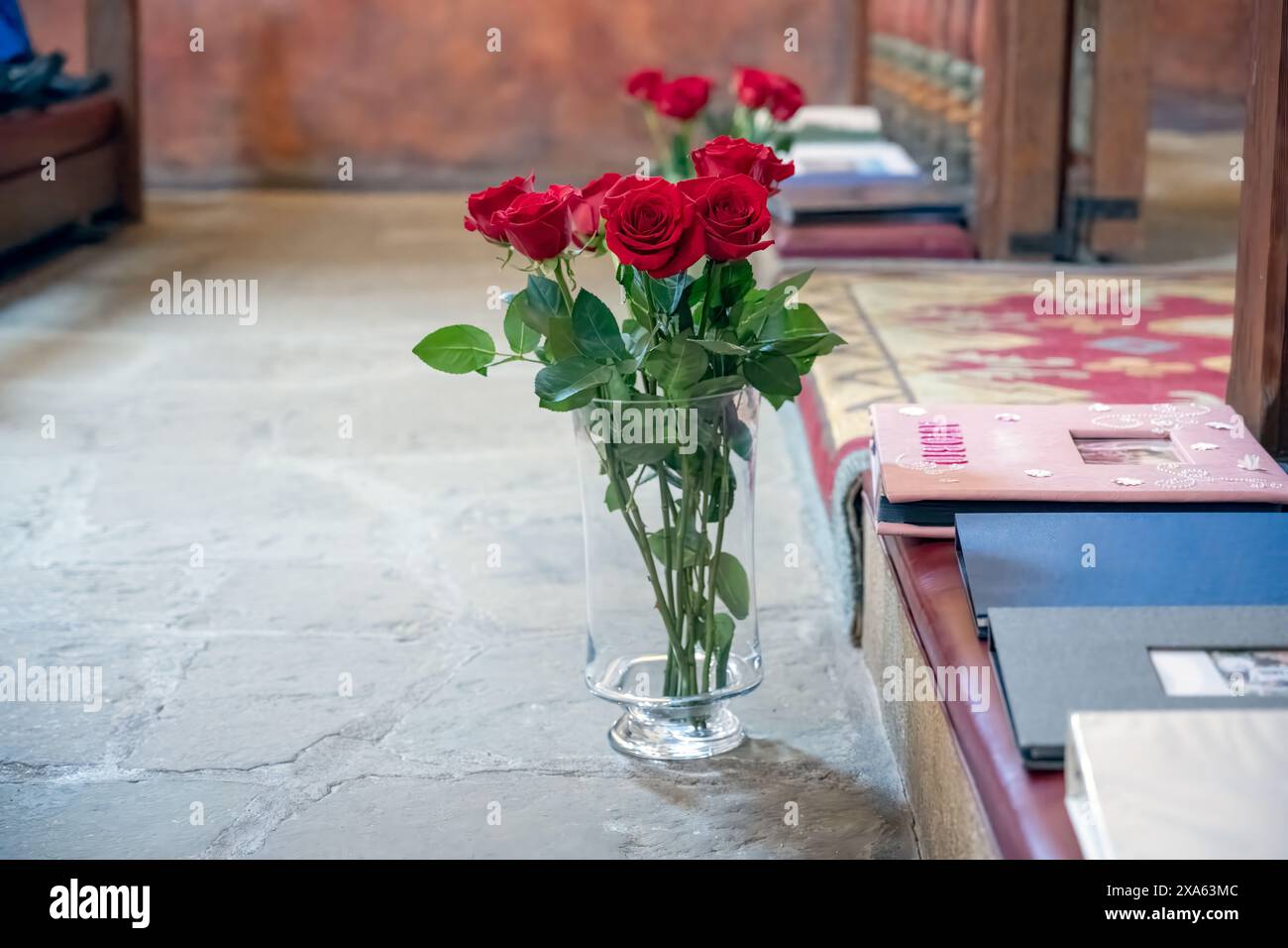 Vases filled with beautiful long stem red roses arranged on the slate ...