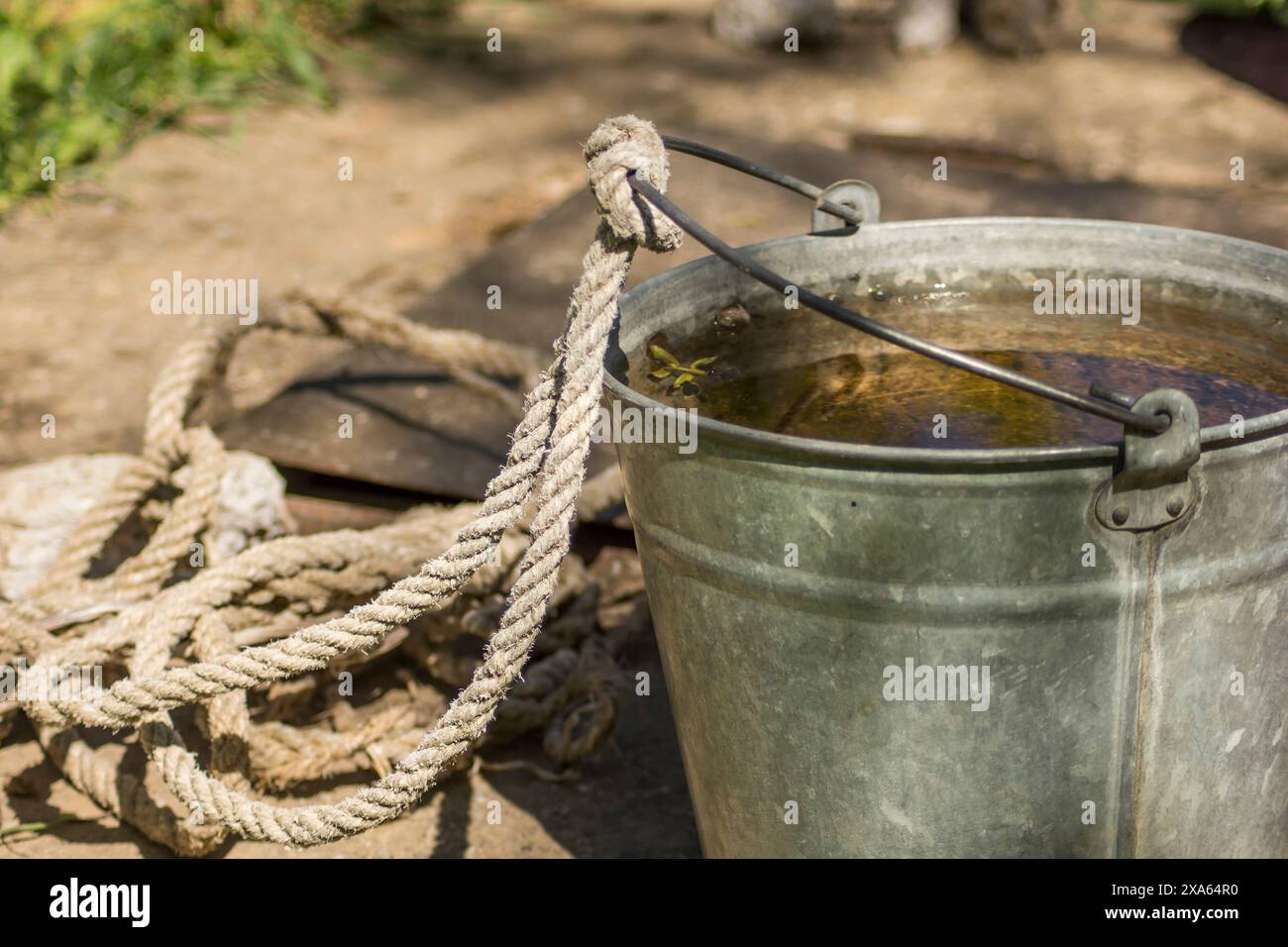 A metal bucket with rope and water inside Stock Photo - Alamy