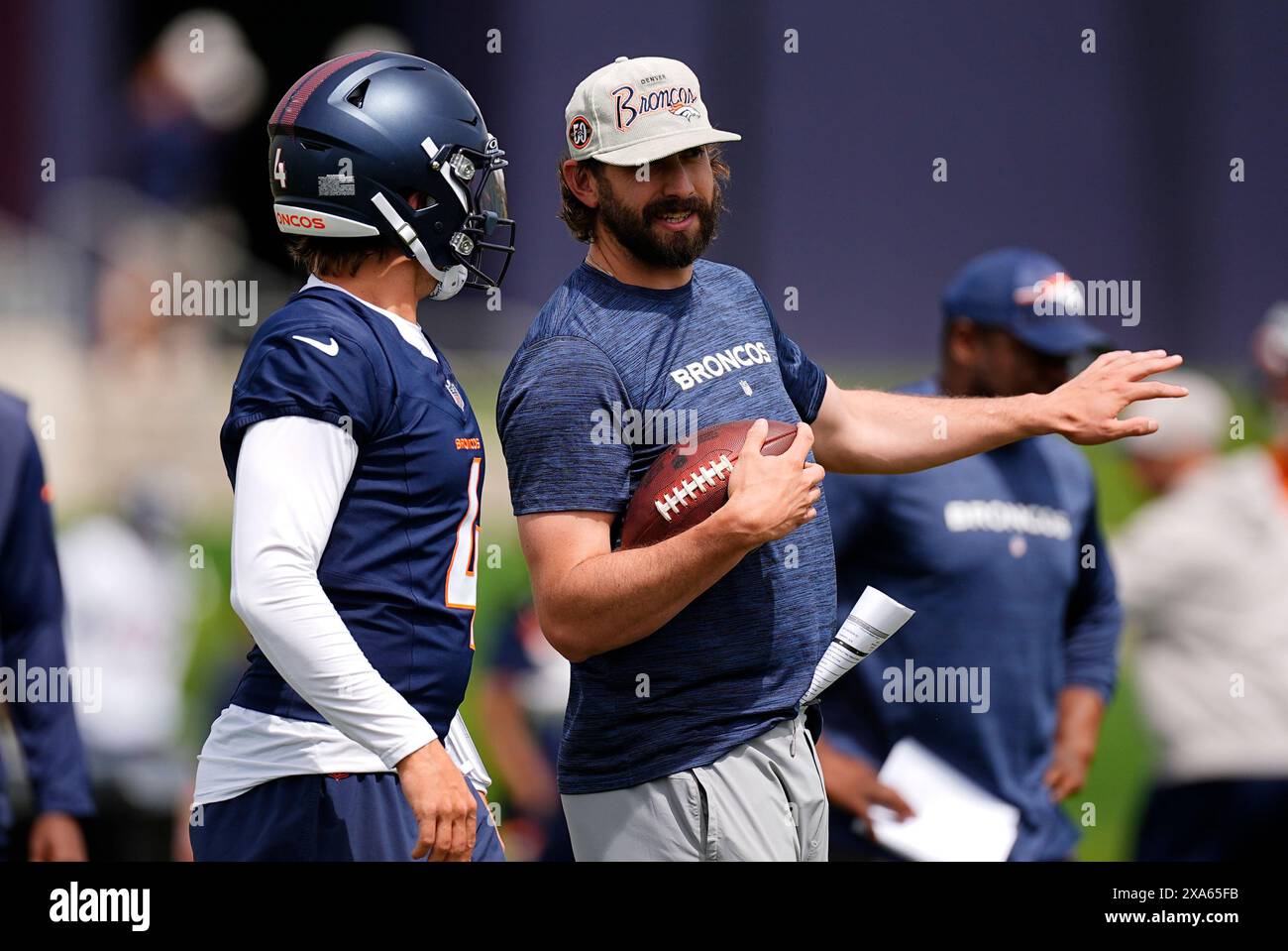 Denver Broncos quarterback coach Davis Webb, right, confers with ...