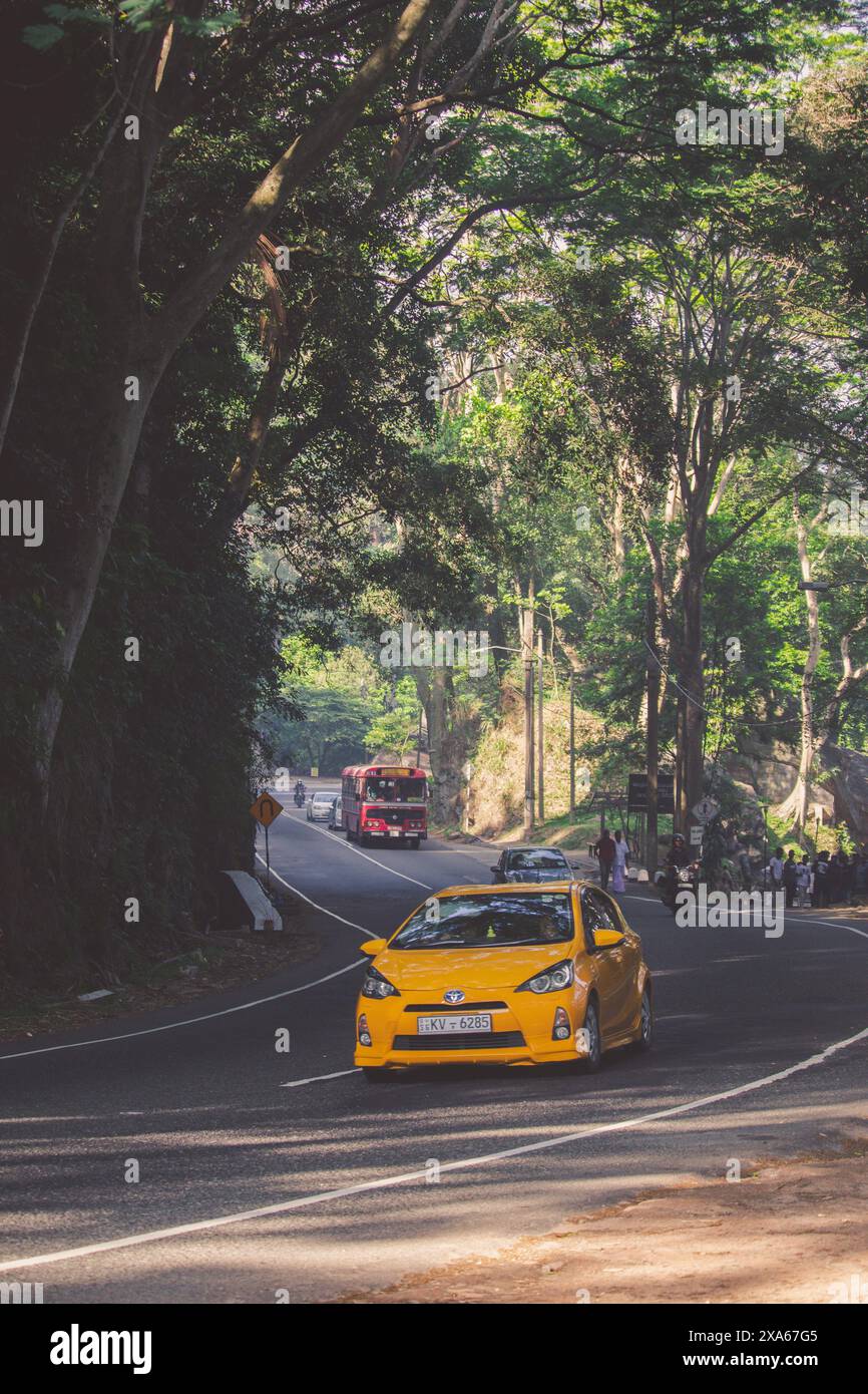 A yellow car cruising on a street with passing vehicles Stock Photo - Alamy