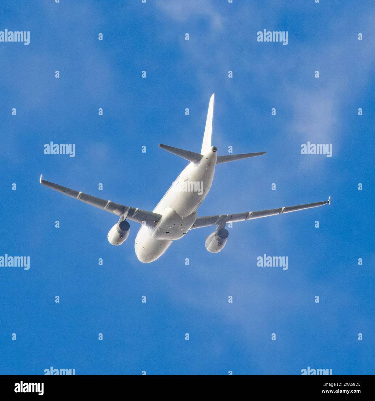 A jet soaring in a clear blue sky with fluffy white clouds Stock Photo ...