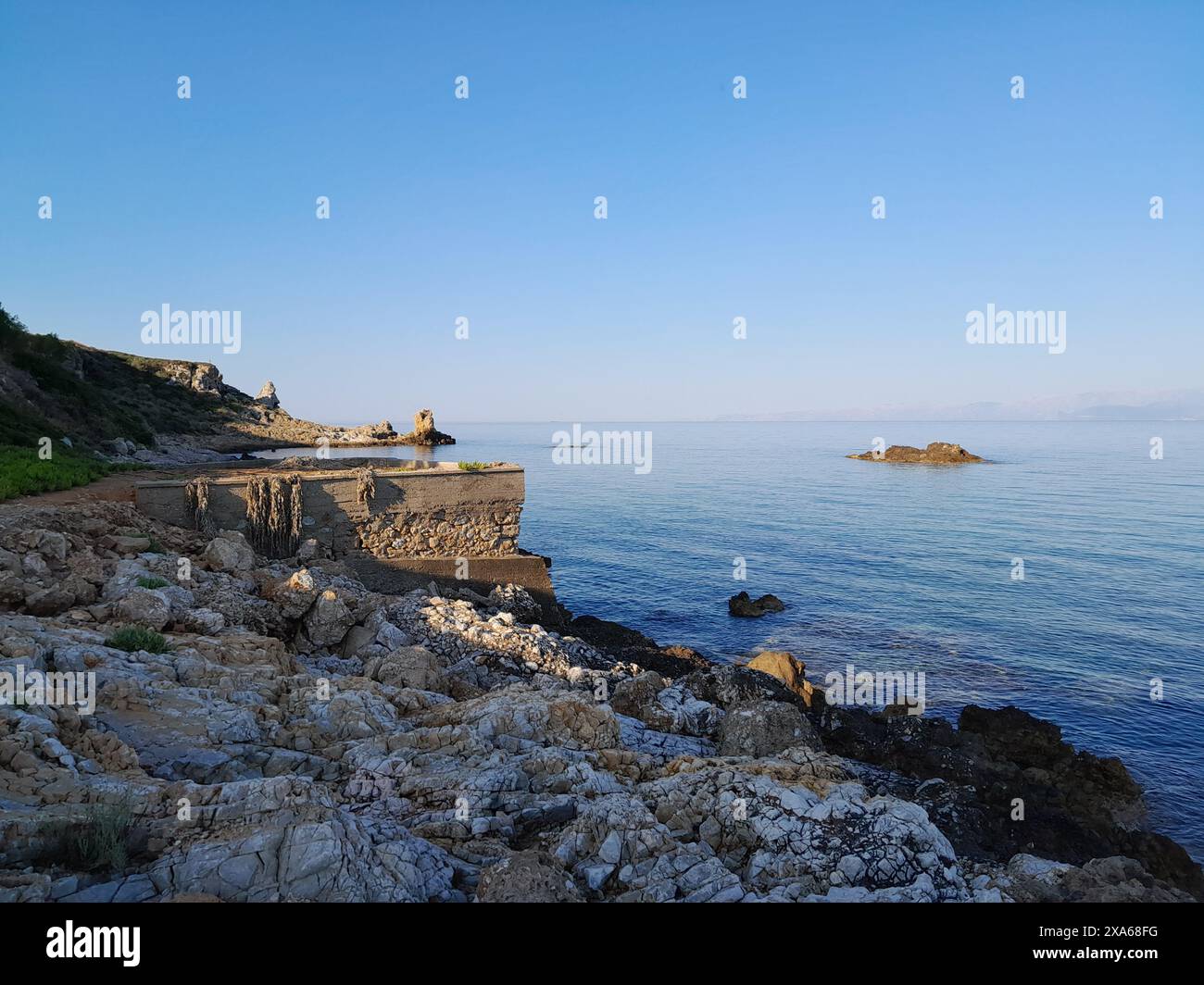 The rocky shoreline of Greece with clear blue waters and skies Stock ...