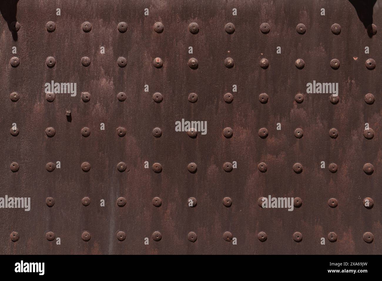 A metal texture on a building wall with multiple holes Stock Photo - Alamy