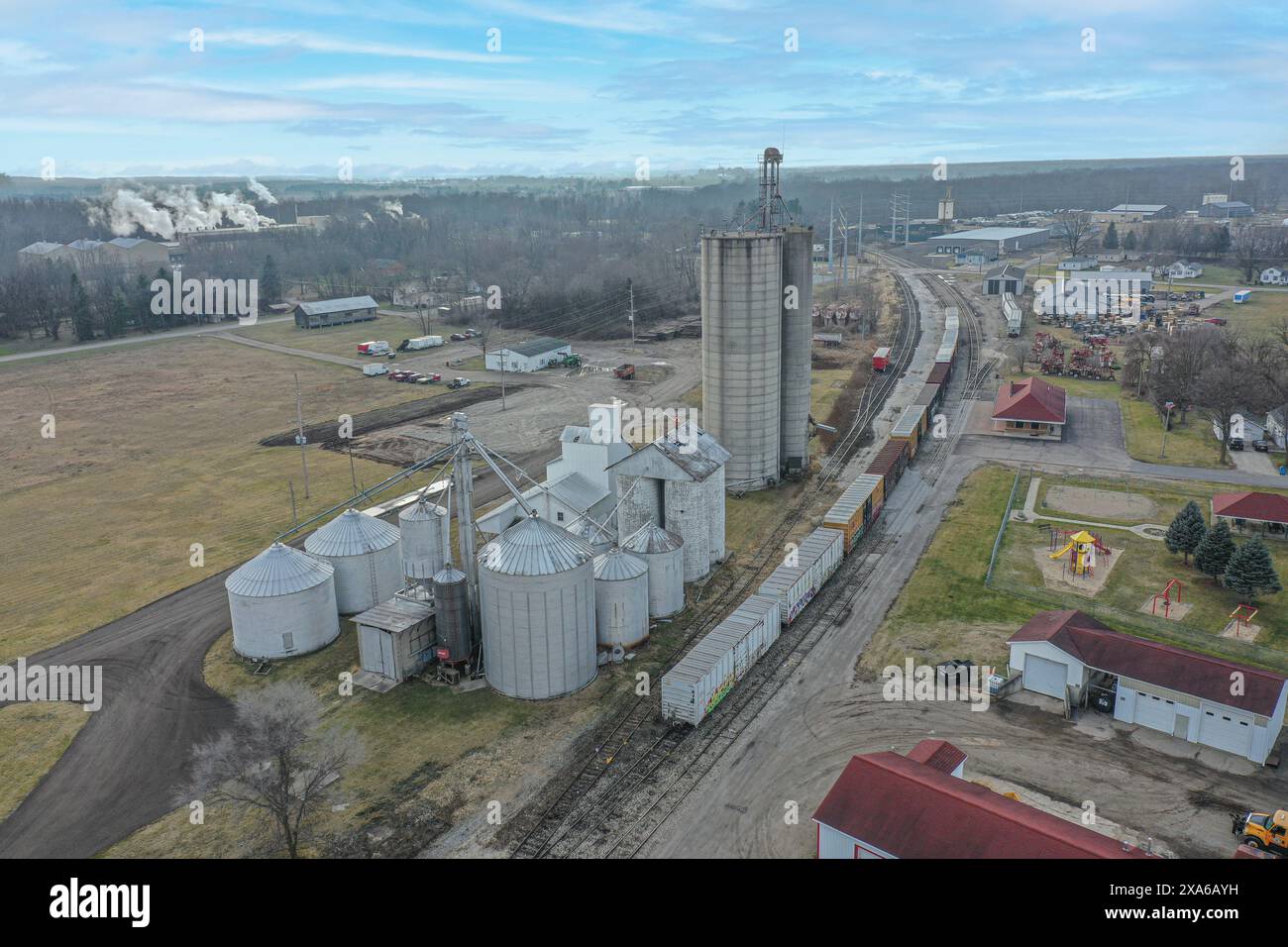 A rural scene with a railway track passing by a grain elevator in an ...