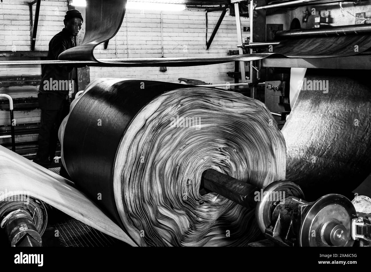 A close-up of rubber roll on conveyor belt machinery at a factory in ...