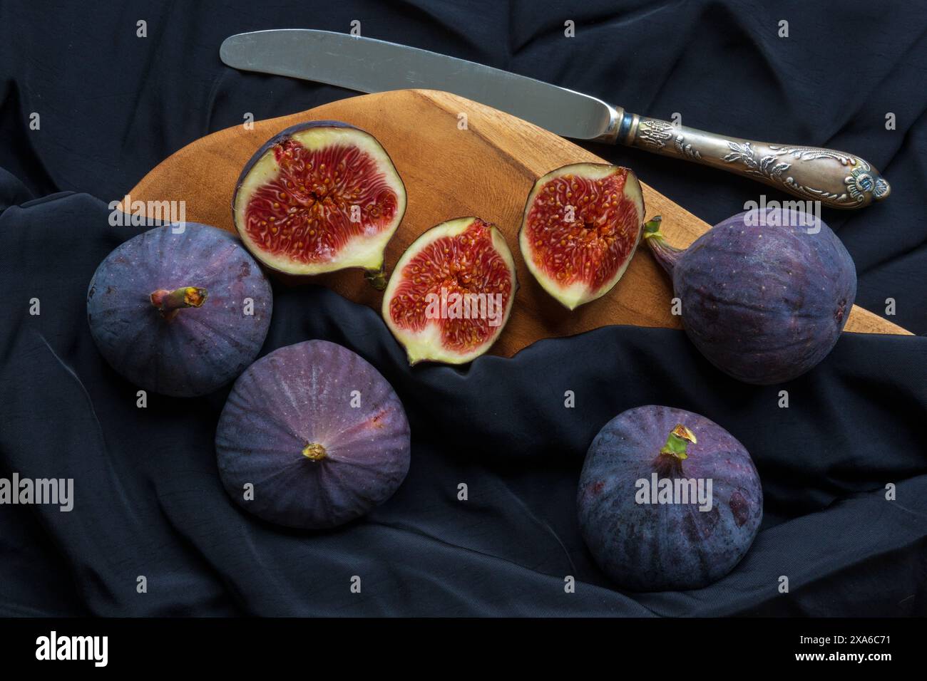 tabletop photo of a group of cut and whole fig fruits with vintage ...