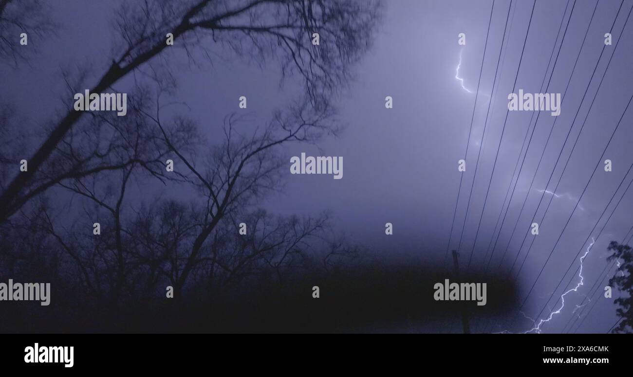 A lightning strike behind power lines during an intense midwest April ...
