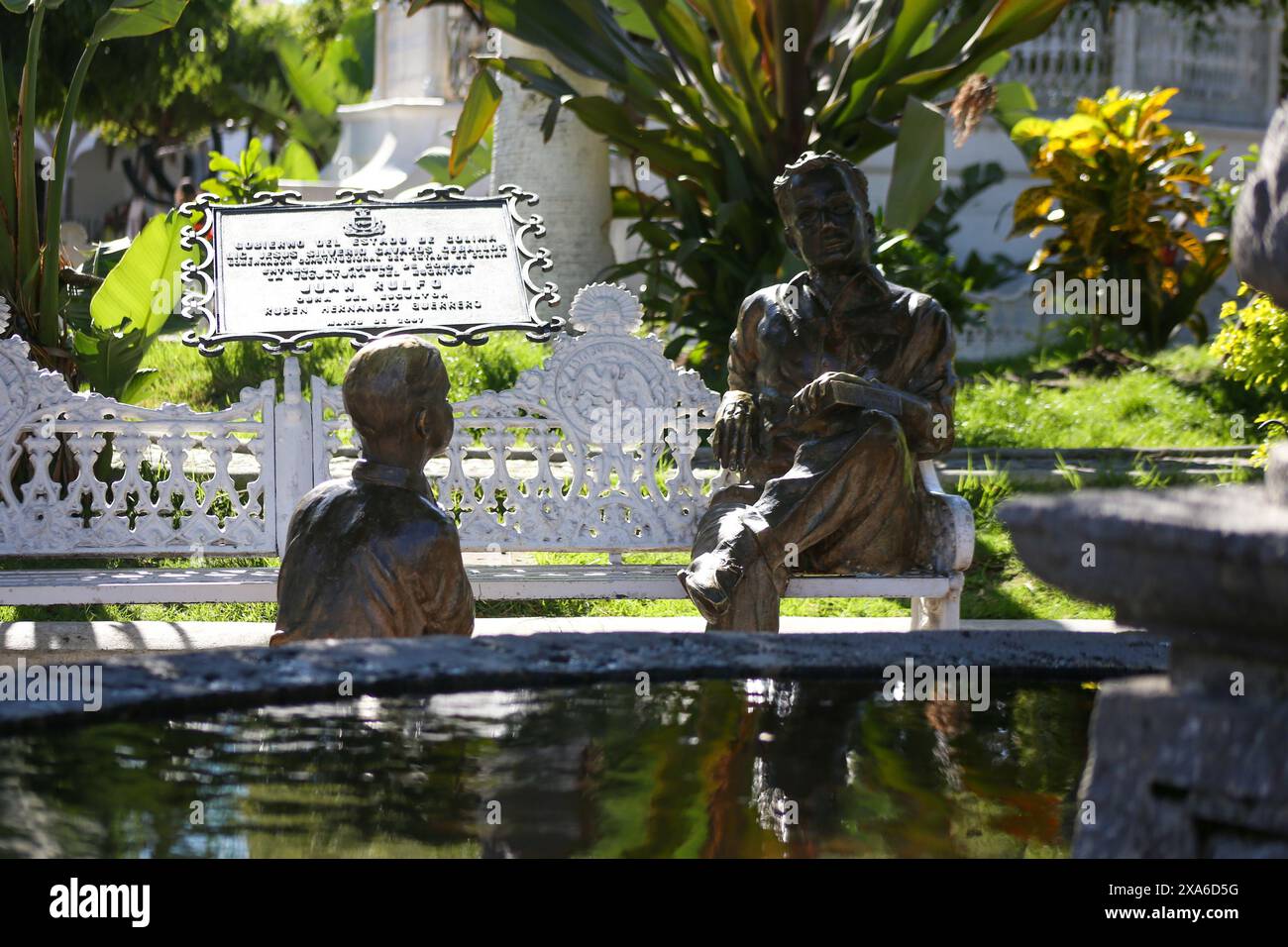 Some statues on bench near fountain, palm trees in yard Stock Photo - Alamy