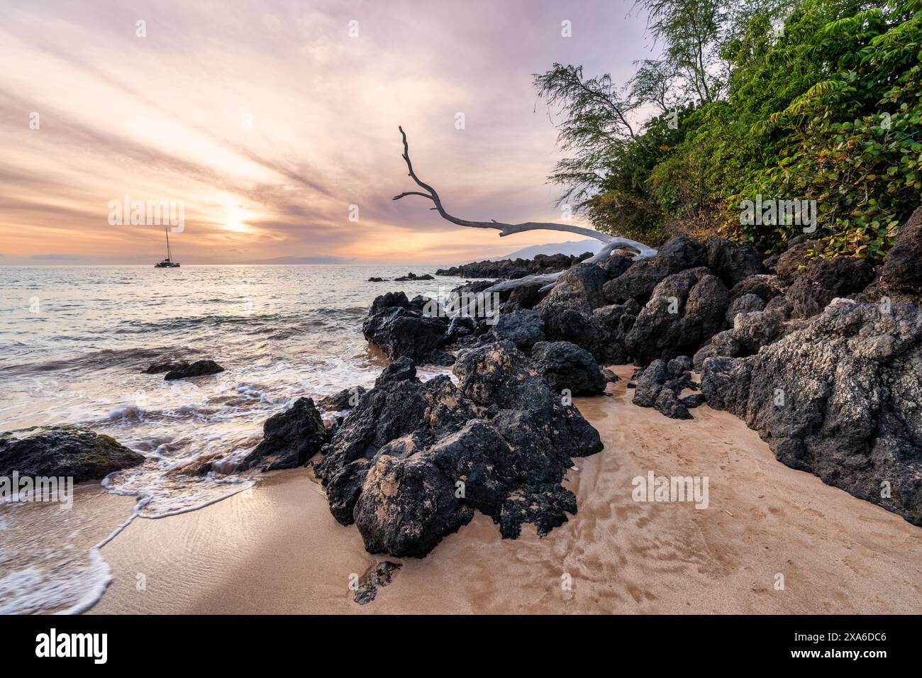 Vibrant sunset casts warm light on ocean shore in Maui, Hawaii Stock ...