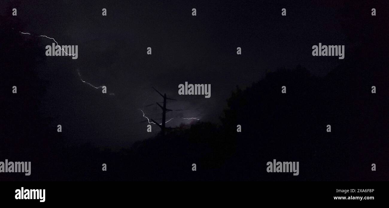 An electric pole under dramatic lightning in the sky Stock Photo - Alamy