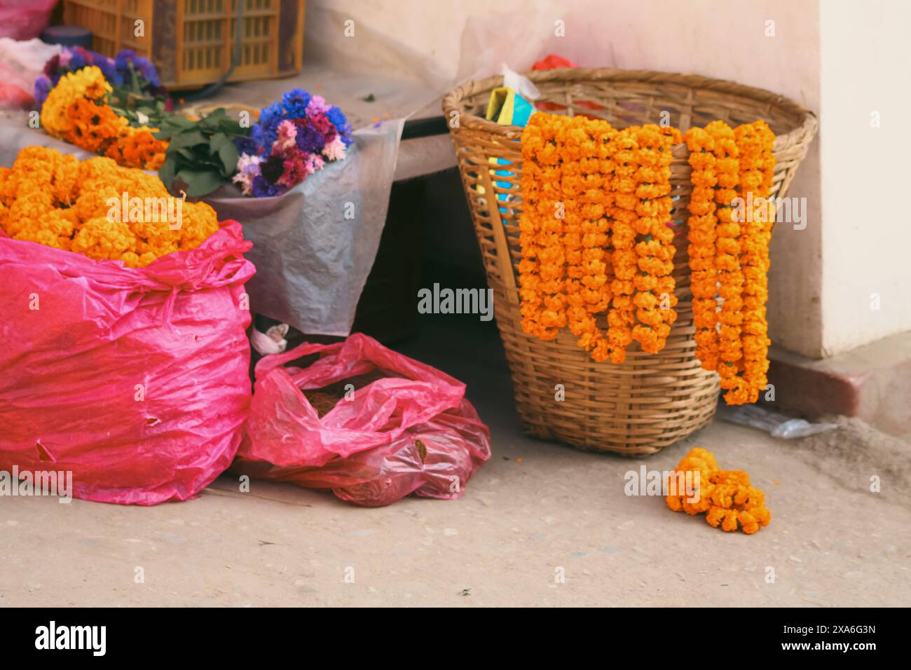 Marigold flowers in plastic bags and garlands hanged on an empty woven ...