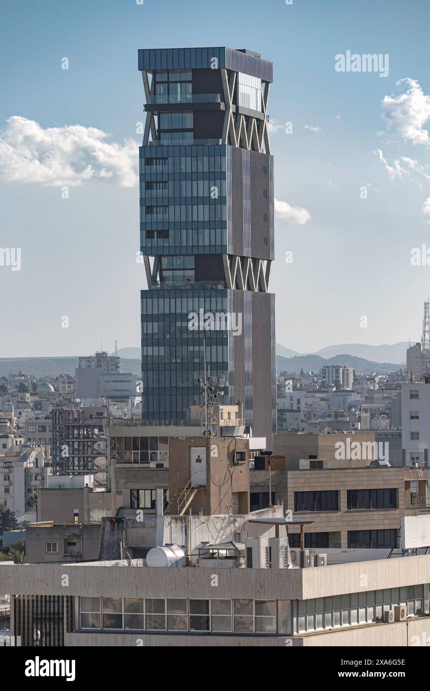Contemporary glass skyscraper towers over an urban skyline of Nicosia ...