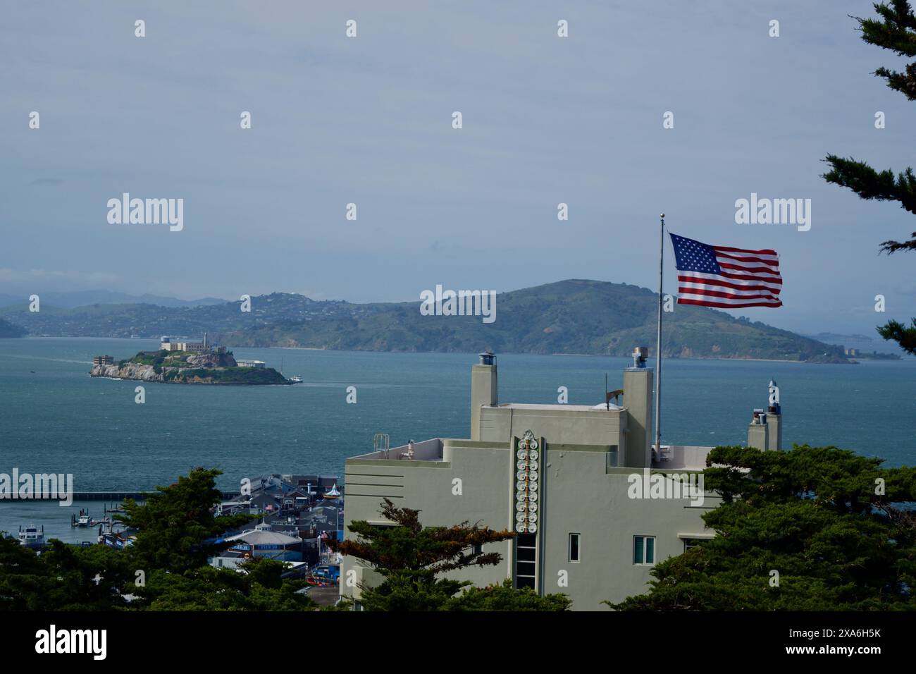 USA Flag floating in the wind with the San Francisco Bay and Alcatraz ...