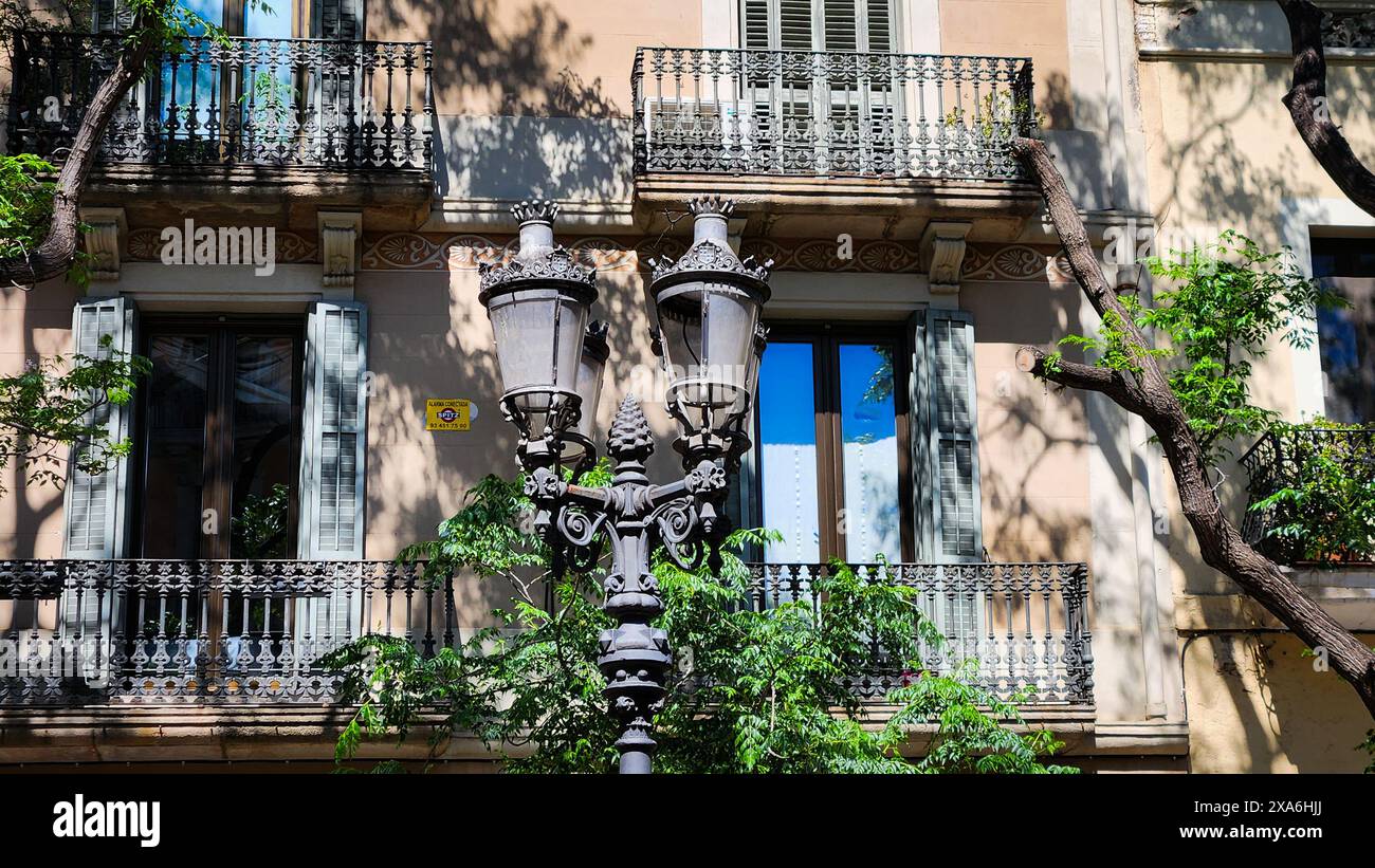 Unique balconies adorn a wall behind a lamp post with Quad lamps Stock ...