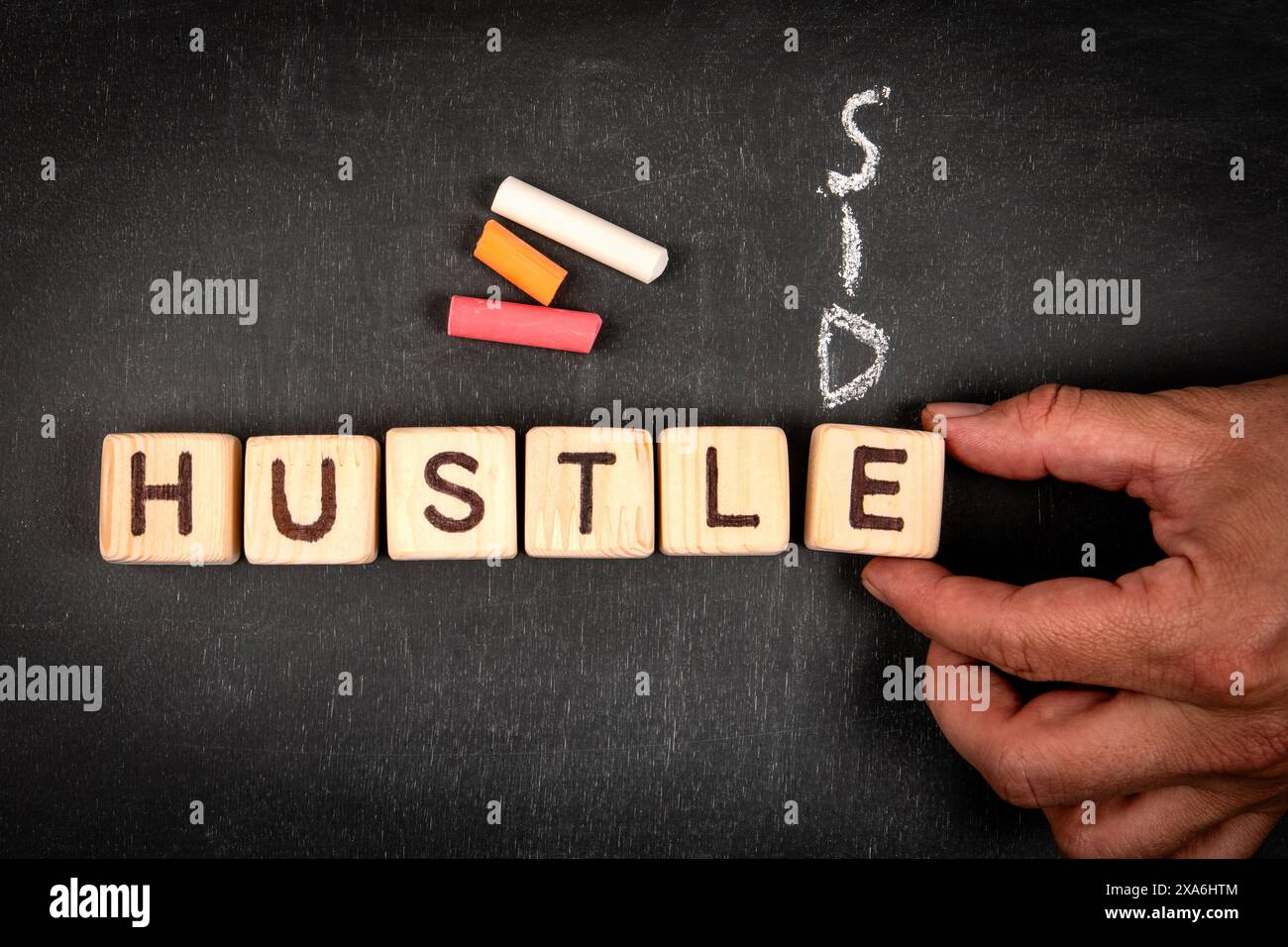 SIDE HUSTLE. Wooden block crossword puzzle and pieces of chalk on a ...