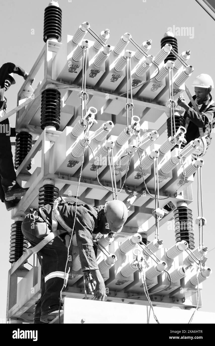 A worker repairing electrical power lines in monochrome, in ...
